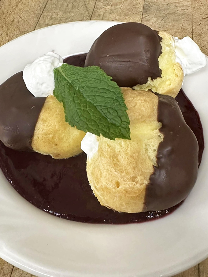 These chocolate-dipped cream puffs aren't just dessert, they're little bites of pure joy with a mint leaf crown.