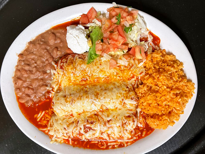 A symphony of red sauce and melted cheese blankets these enchiladas, while Mexican rice plays the perfect supporting role.