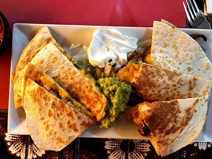 Golden-brown tortillas reveal their treasure of melted cheese and fillings, with fresh guacamole standing by for the perfect bite.
