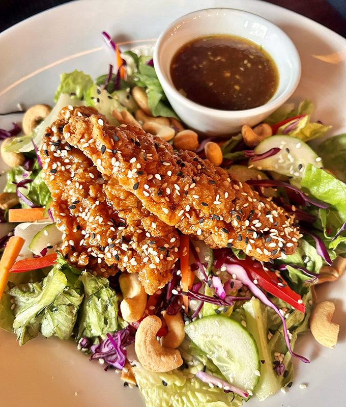 Asian-inspired crispy chicken atop fresh greens - because sometimes you need to pretend you're eating healthy while indulging.