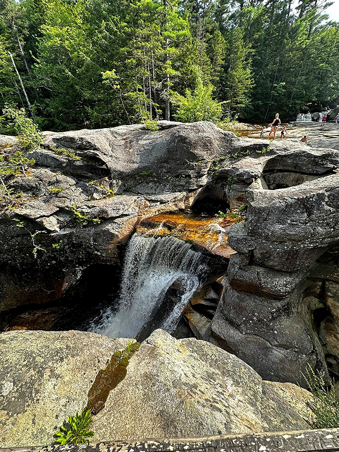 Water dances over ancient rock formations, creating a natural light show as sunlight catches each droplet.