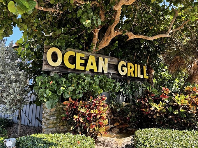 Nature's own welcome mat: lush greenery framing a sign that promises oceanic delights. Talk about curb appeal!