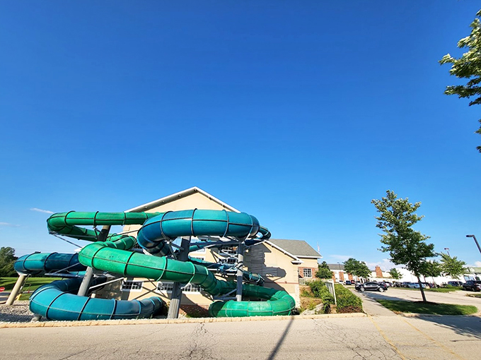 Bright green and blue slides create a playful contrast against the industrial-chic indoor setting.