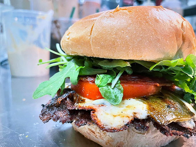 Fresh greens and ripe tomatoes add a garden-fresh crunch to this perfectly charred burger &ndash; nature and nurture in perfect harmony. Photo credit: Backwoods Burger Shack
