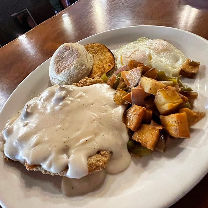 Country-style gravy blankets a golden-fried masterpiece, while seasoned potatoes stand ready for their moment of glory. Photo credit: 5th Avenue Cafe