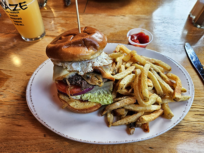 A perfectly stacked burger shares the plate with those famous fries, creating the ultimate comfort food duo.