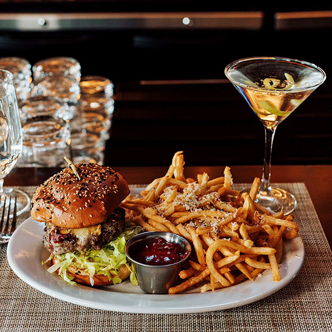 This burger isn't just a meal, it's an engineering marvel - stacked tall and proud with golden fries standing guard. Photo credit: Nick's Steakhouse