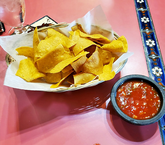Crispy, house-made tortilla chips meet their match in a stone bowl of vibrant salsa - simple perfection at its finest.