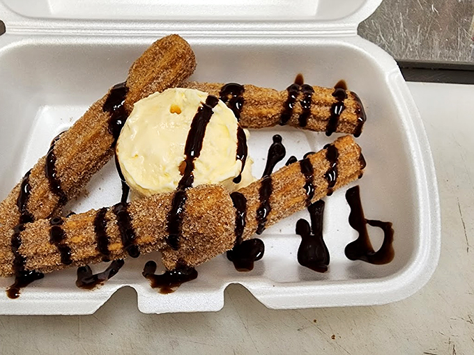 Golden-brown churros drizzled with chocolate sauce and paired with ice cream - a classic combo that never disappoints.