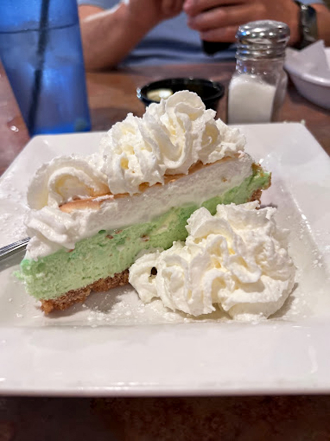 A slice of heaven: creamy mint-green cheesecake crowned with pillowy whipped cream that would make angels sing.