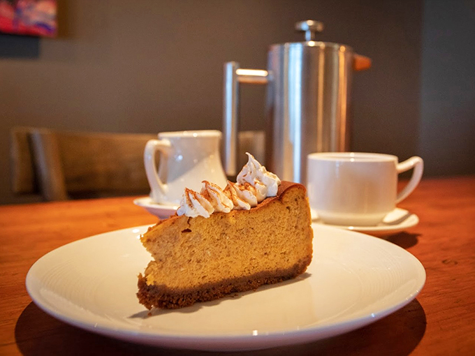 A slice of heaven: creamy cheesecake topped with delicate whipped cream peaks, perfect with that last cup of coffee.