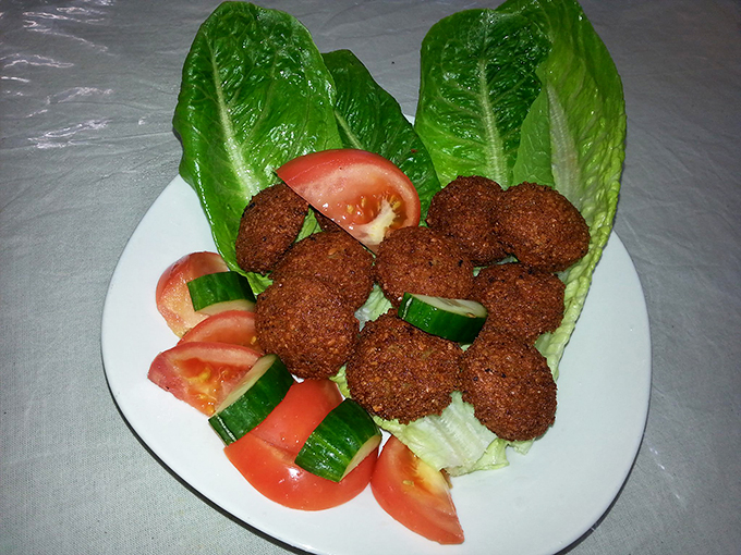 These aren't your average falafel - they're crispy orbs of chickpea perfection, nestled on fresh lettuce like jewels on velvet.