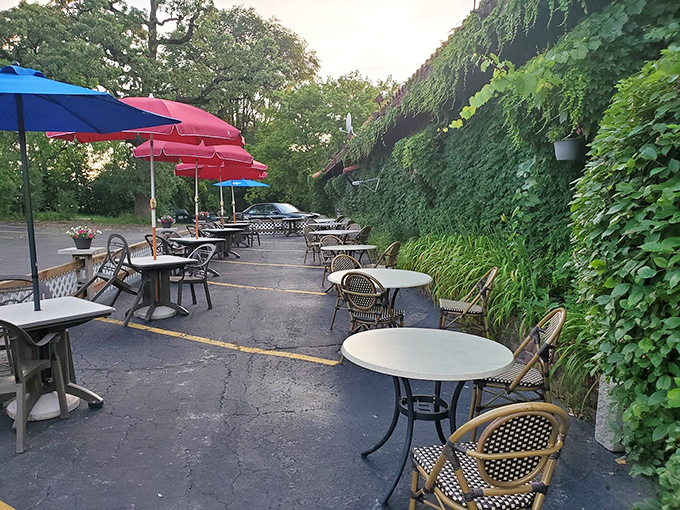 Red umbrellas dot this peaceful patio space where ivy-covered walls create an escape from the everyday.