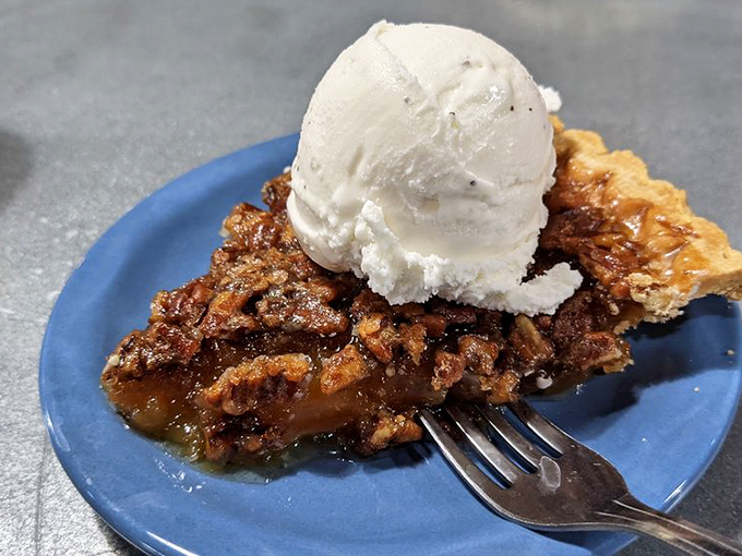 A perfect slice of pecan pie crowned with vanilla ice cream&mdash;proof that happiness can be served on a plate.