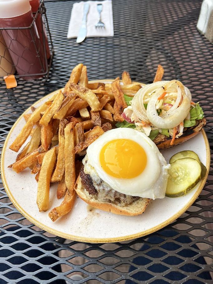 The sunny-side-up egg perches atop this pork burger like a golden crown, ready to create its own delicious sauce.