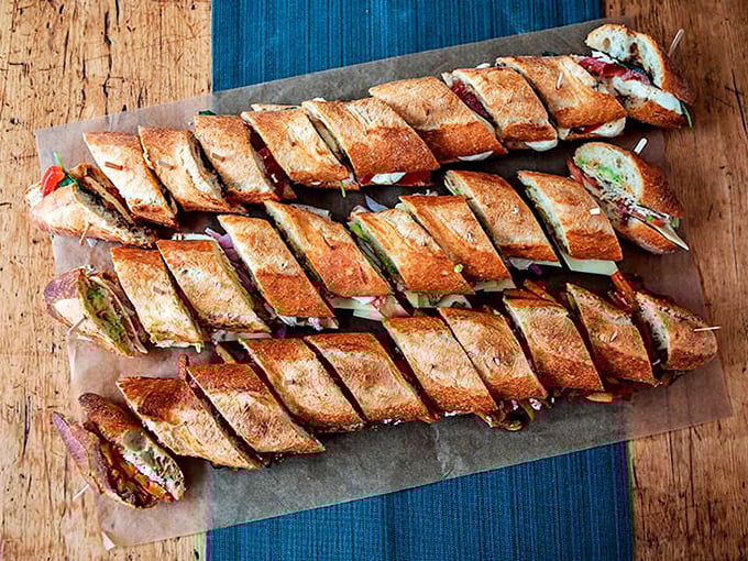 Artfully sliced baguette sandwiches lined up like delicious dominos, ready to make your lunch spectacular.