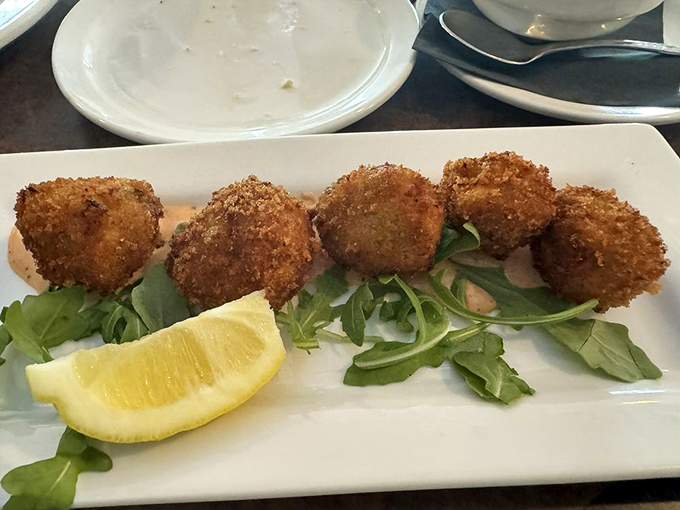 Conch fritters that could make a mermaid jealous. Golden, crispy, and served with a zesty sauce &ndash; these little bites pack a big flavor punch. Photo credit: Jenette S.