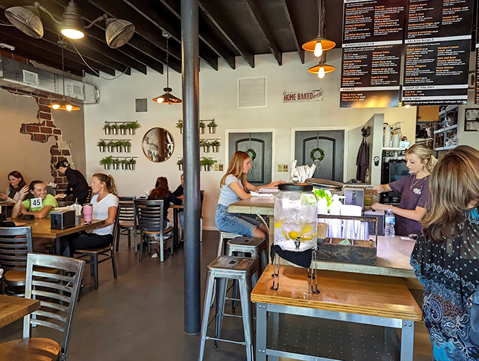 Modern industrial meets coastal charm in this airy space, where potted herbs and string lights create a welcoming vibe.
