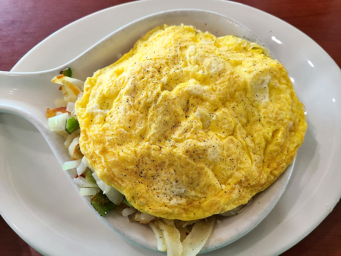 Behold the omelet that ate Manhattan! This cheesy, veggie-packed wonder is a breakfast skillet that dreams are made of.