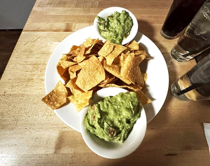 Fresh tortilla chips flank two generous portions of house-made guacamole - simple perfection that needs no fancy introduction.