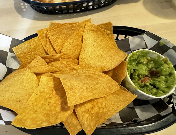 Fresh tortilla chips arranged like sun rays around their creamy green companion. A classic combo that never goes out of style.