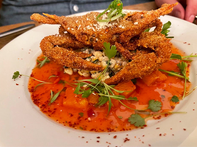 Crispy soft-shell crab perches atop a vibrant orange sauce like modern art you can actually eat. Photo credit: Joseph N.