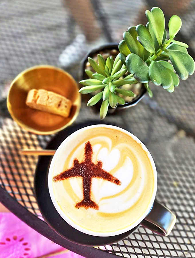 Coffee art that pays homage to its aviation setting, complete with a perfectly crafted plane design in the foam.