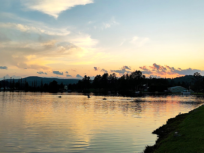 Golden hour at Joe's Pond turns the water into liquid amber, while silhouetted kayakers glide through nature's light show.