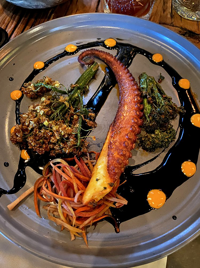 This grilled octopus tentacle, surrounded by colorful accompaniments, looks like it could tell tales of its ocean adventures. Photo credit: Michael R.