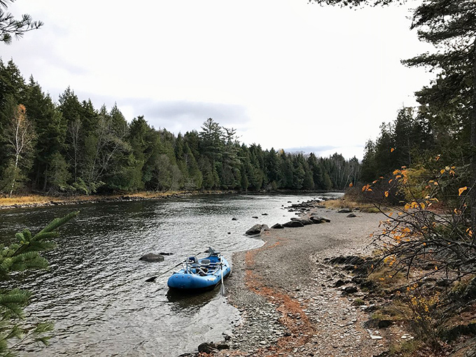 A peaceful river moment captured: where adventure meets serenity, and a blue raft waits for its next story.