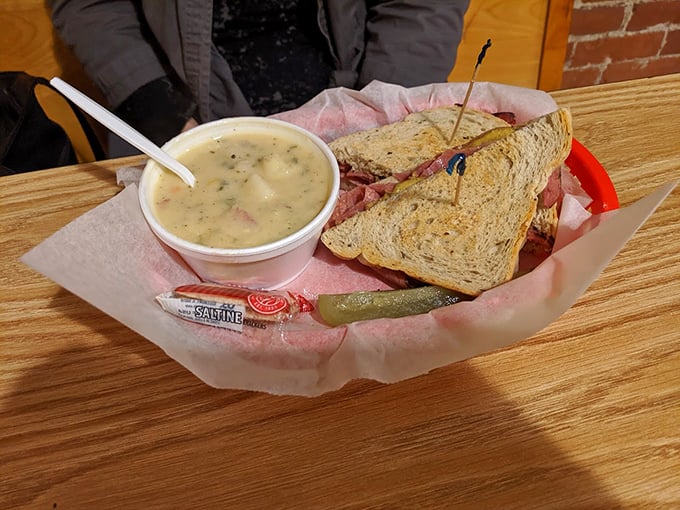 A pickle stands guard beside this perfect pairing of sandwich and soup, ready for its supporting role in your lunch.