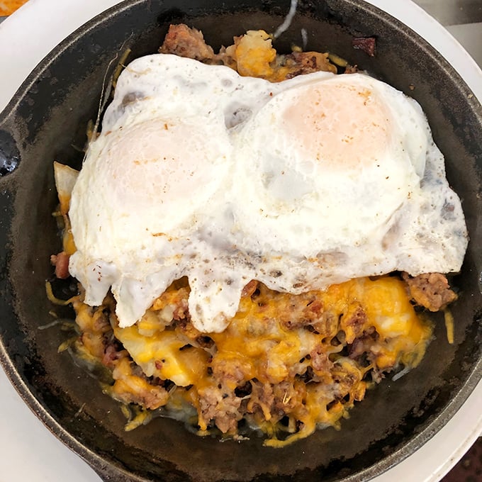 This skillet is like a treasure chest for your taste buds. Dig in and discover golden potatoes, savory meats, and eggs that could make a rooster crow with pride.