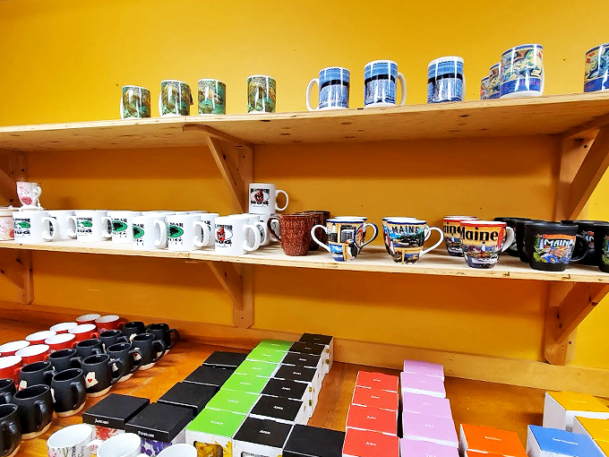 A rainbow of Maine mugs tells stories of lighthouses and lobsters, perfect for sipping morning coffee with a side of nostalgia.
