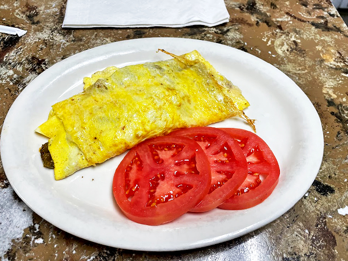 Egg-cellence folded to perfection! This omelet is so stuffed with goodies, it's like a pillow fight at a veggie convention.