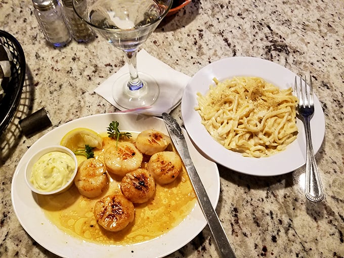 Seared scallops swimming in buttery sauce, paired with creamy pasta - proof that lakeside dining can rival any coastal experience.