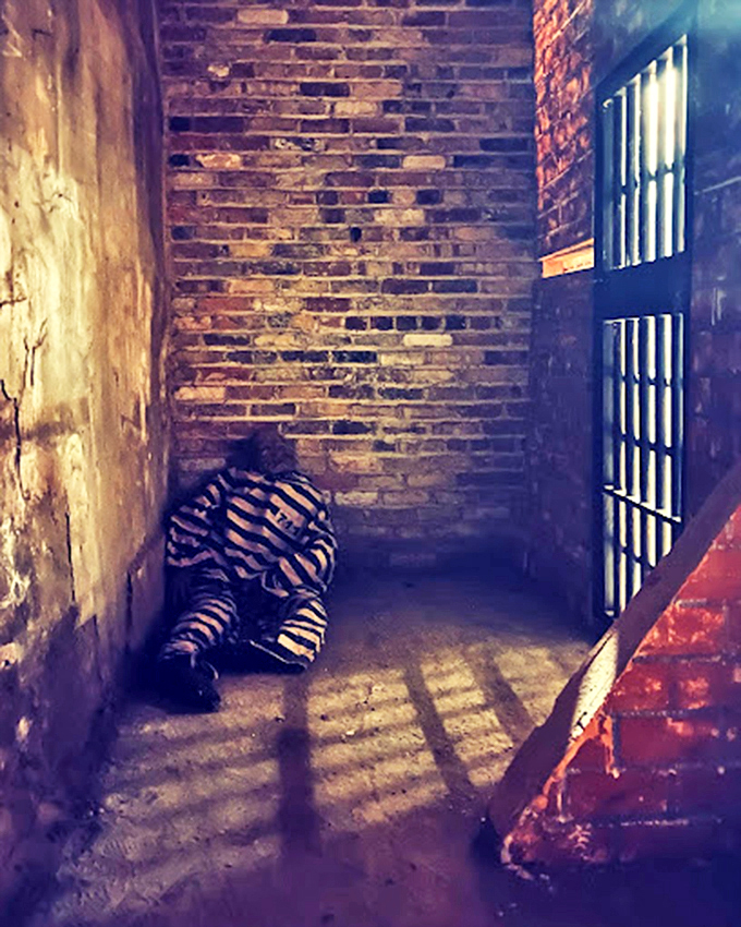 Moonlight casts eerie shadows on these weathered walls, where history and hauntings go hand in cuffed hand.