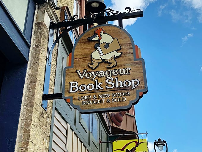 Follow the book-toting fox to literary treasure! Voyageur's whimsical sign promises rare finds and page-turning excitement.