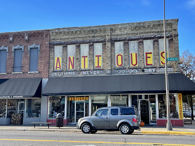 "Antiques" in lights: Where nostalgia meets brick and mortar. This storefront promises a journey through time, no DeLorean required.