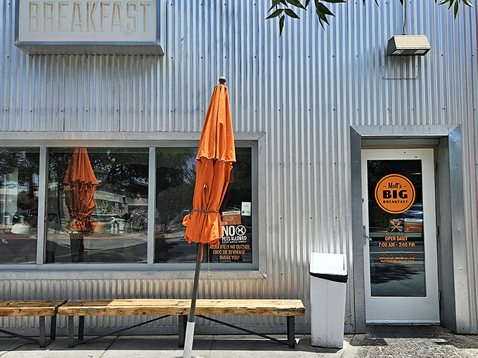 Matt's Big Breakfast: Industrial chic meets morning comfort. Corrugated metal exterior, orange umbrellas, and inviting windows promise a unique dining experience in this urban breakfast haven.