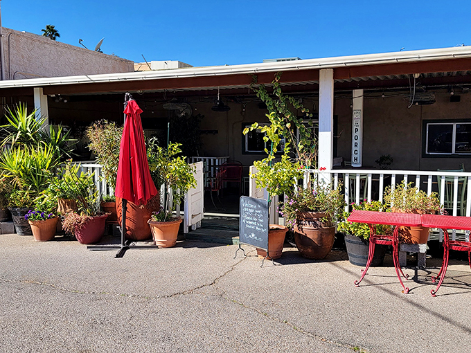 Welcome to flavor town! Big House Cafe's charming exterior promises a cozy retreat from the Arizona heat, complete with potted plants and a cheery red umbrella.