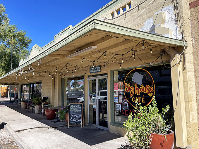Welcome to flavor town! Big House Cafe's charming exterior promises a cozy retreat from the Arizona heat, complete with potted plants and string lights.