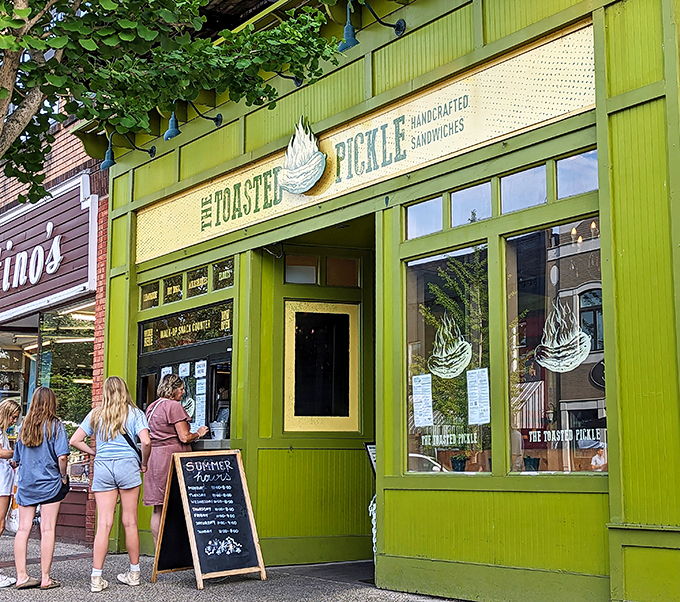 A pickle paradise in vibrant green! The Toasted Pickle stands out like a beacon of briny brilliance on this charming Grand Haven street.