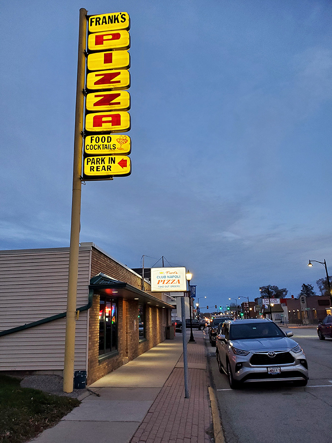 "Pizza this way!" The neon sign beckons like a lighthouse for hungry sailors, promising cheesy salvation just around the corner.