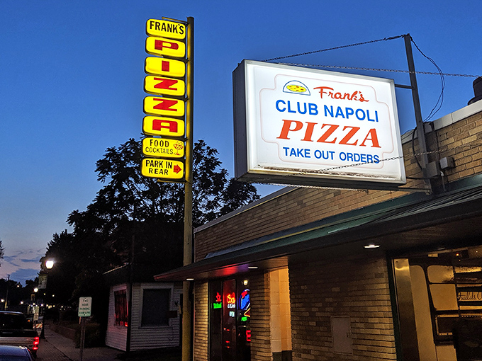 "Pizza this way!" The neon sign beckons like a lighthouse for hungry sailors, promising cheesy salvation just around the corner.