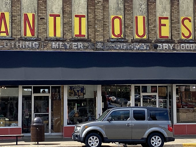 "Antiques" in lights: Where nostalgia meets brick and mortar. This storefront promises a journey through time, no DeLorean required.