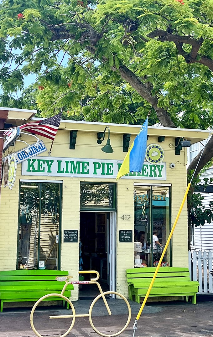 Welcome to Key West's citrus-scented paradise! The Original Key Lime Pie Bakery's cheerful yellow facade and vibrant green benches beckon like a tropical siren song.