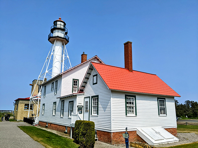 A postcard come to life! Whitefish Point Lighthouse stands tall, its red-roofed keeper's quarters a cozy contrast to Lake Superior's vast expanse.