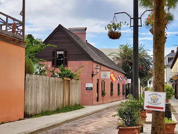 Pink perfection on a cobblestone street! This charming facade is like a dollhouse for history buffs &ndash; complete with hanging baskets and colonial flair.