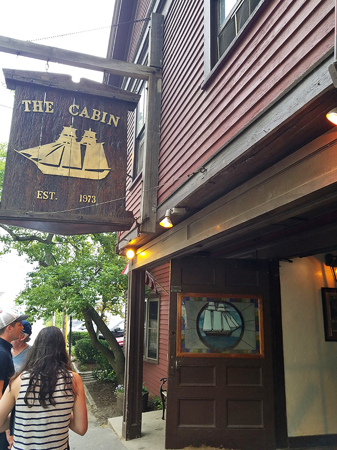 Ahoy, food lovers! The Cabin's weathered sign promises a voyage of flavor, with its golden ship sailing through time since 1973.