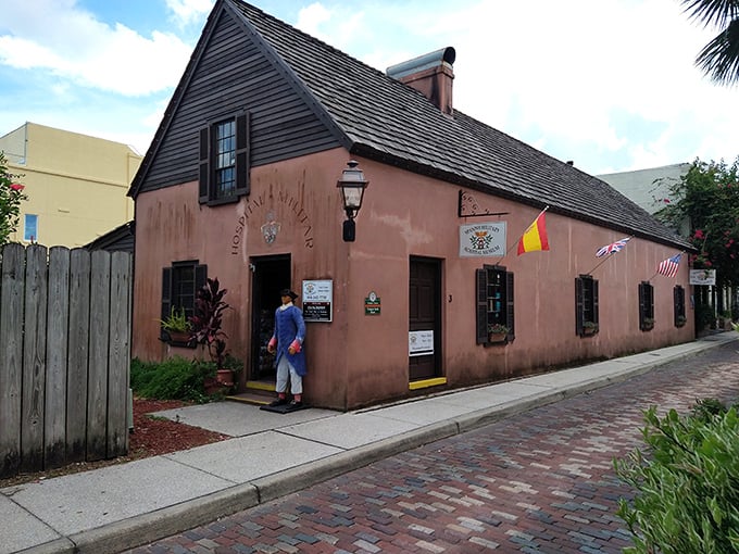 Pink perfection on a cobblestone street! This charming facade is like a dollhouse for history buffs &ndash; complete with hanging baskets and colonial flair.